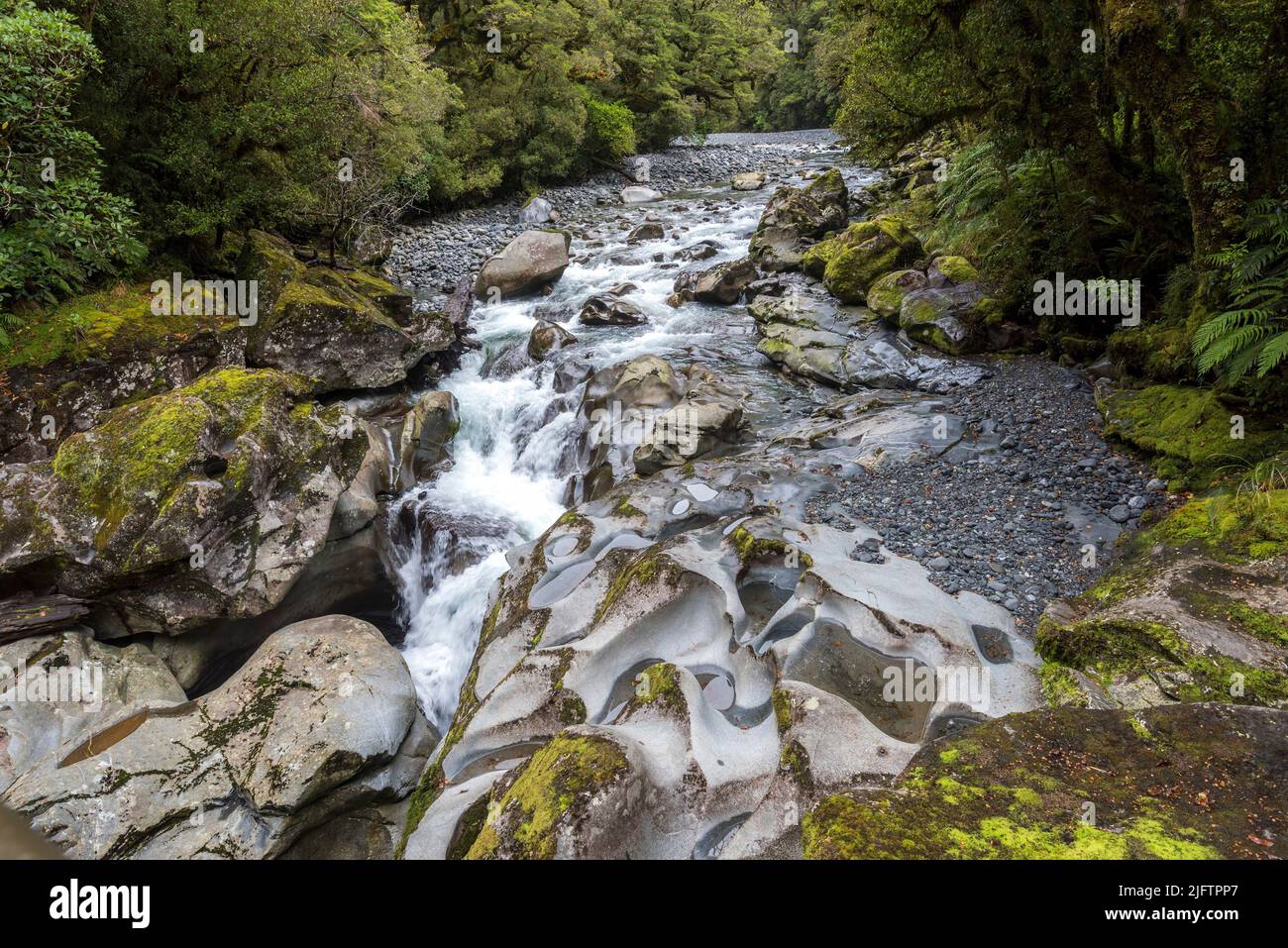 A breathtaking view of The Chasm flowing through moss-covered rocks in ...