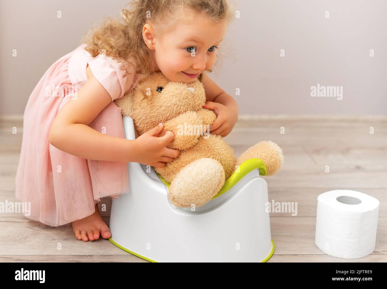 The child puts the toy on the potty Stock Photo - Alamy