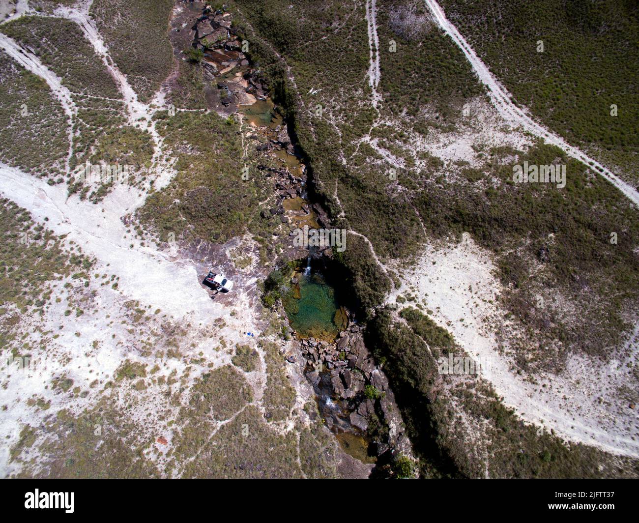 An aerial shot of a river with almost no water and snowy patches on the ...