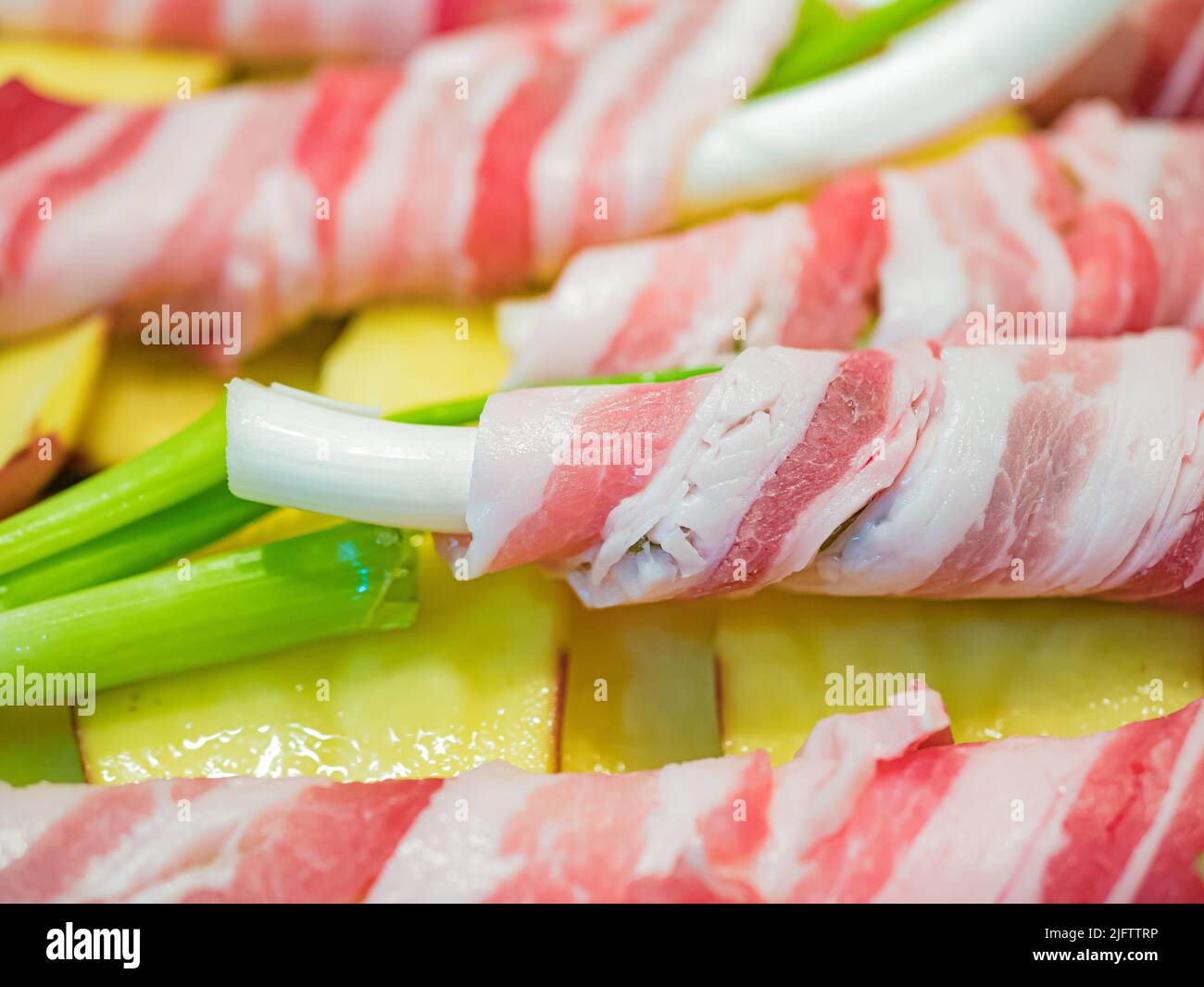 Raw spring onion with rolled bacon. Typical Sicilian street dish called ...
