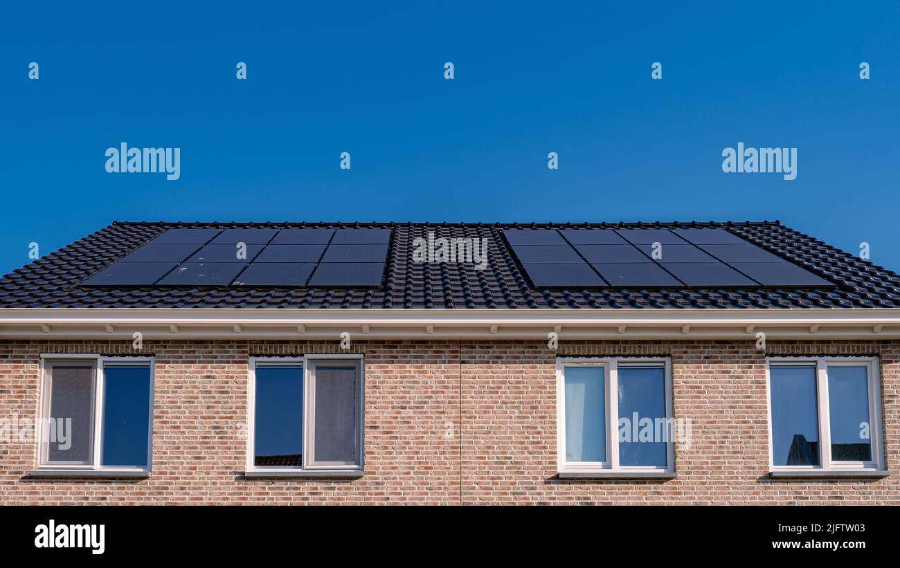 Newly build houses with solar panels attached on the roof against a ...