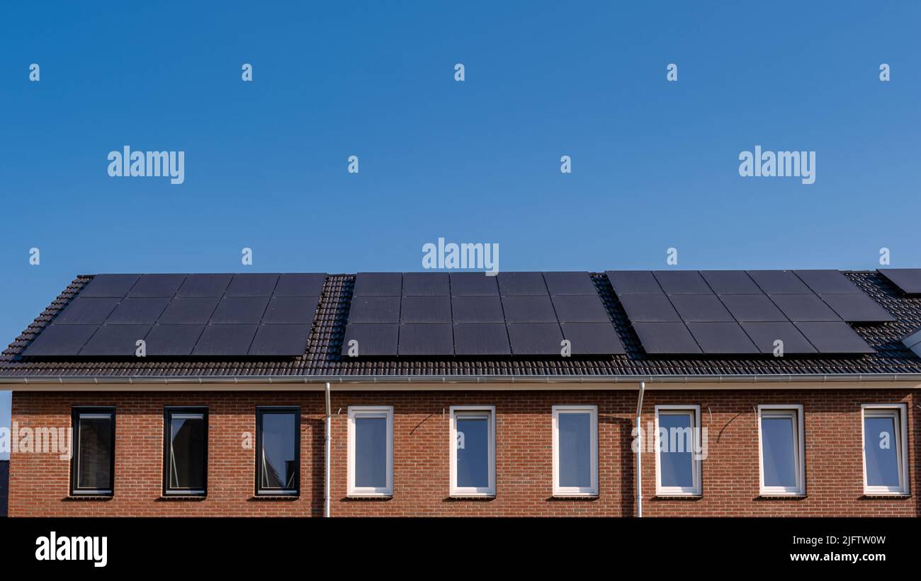 Newly build houses with solar panels attached on the roof against a ...