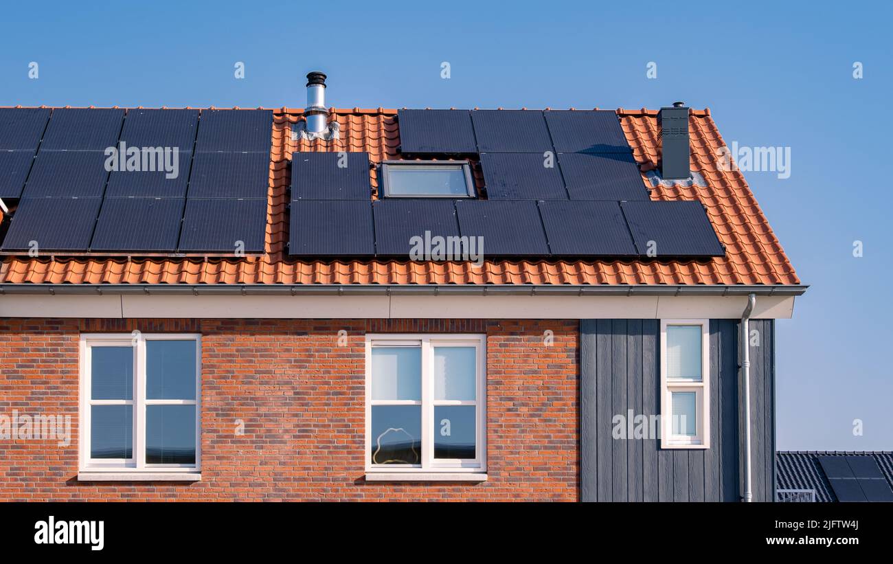 Newly build houses with solar panels attached on the roof against a ...