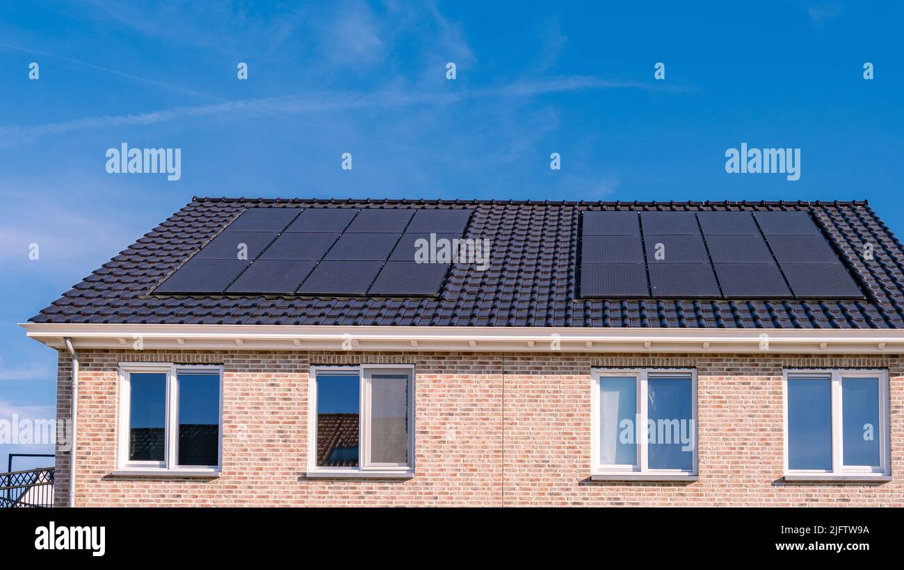 Newly build houses with solar panels attached on the roof against a ...