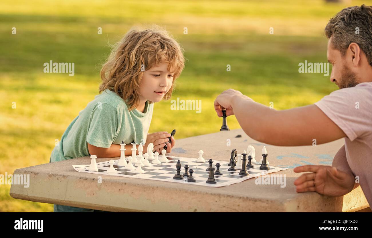 strategic and tactic. tutorship. dad and kid play logic game. father and son playing chess ...