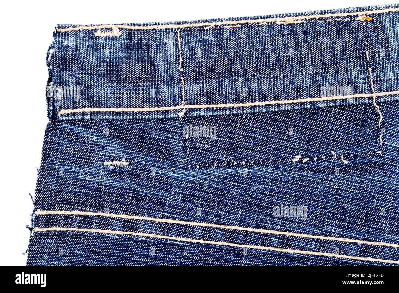 Piece of blue jeans fabric with a ripped of back label isolated on ...