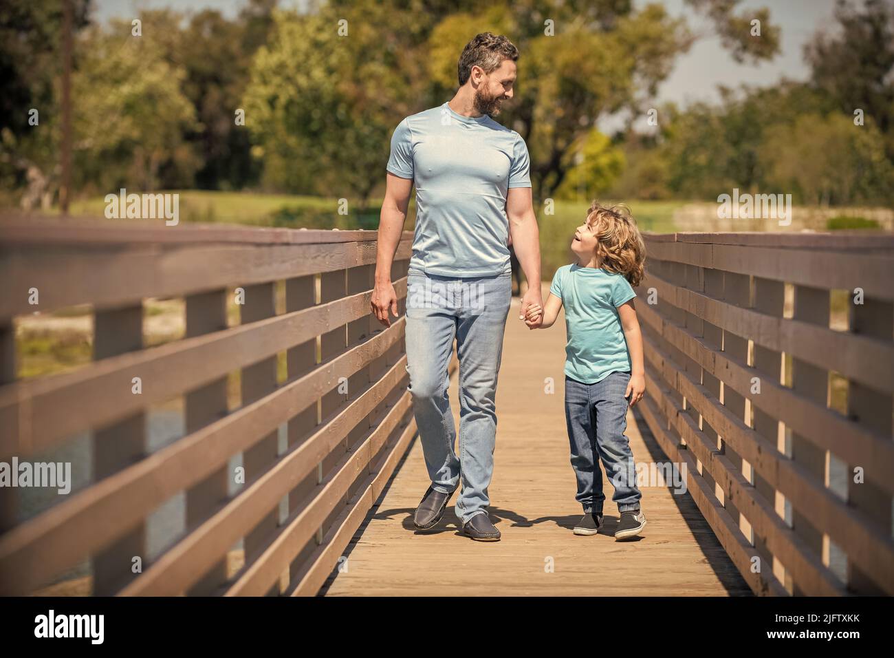 cheerful single father leading small child outside, charity Stock Photo ...