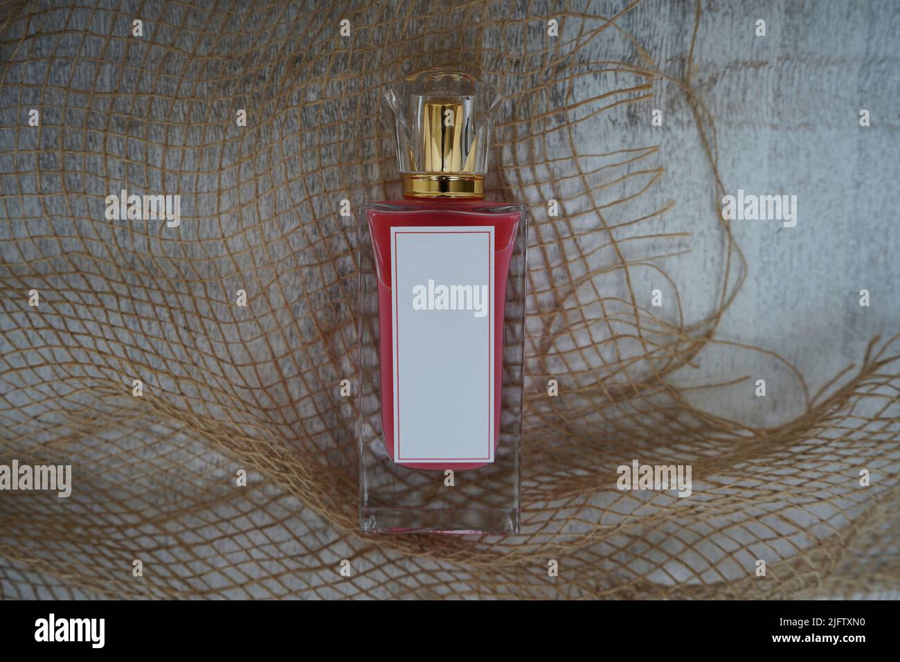 red fragrance perfume bottle with white blank rectangle and gold cap ...