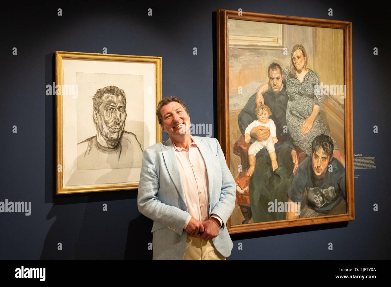 Alex Boyt, son of Lucien Freud stands in front of a portrait of himself ...