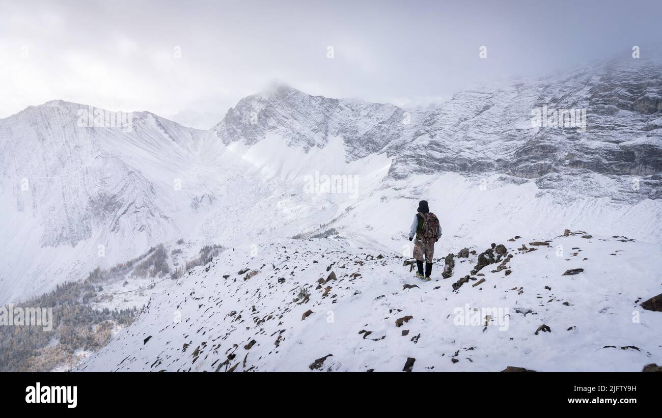 Hiker descending from the mountain during winter, narrow shot ...