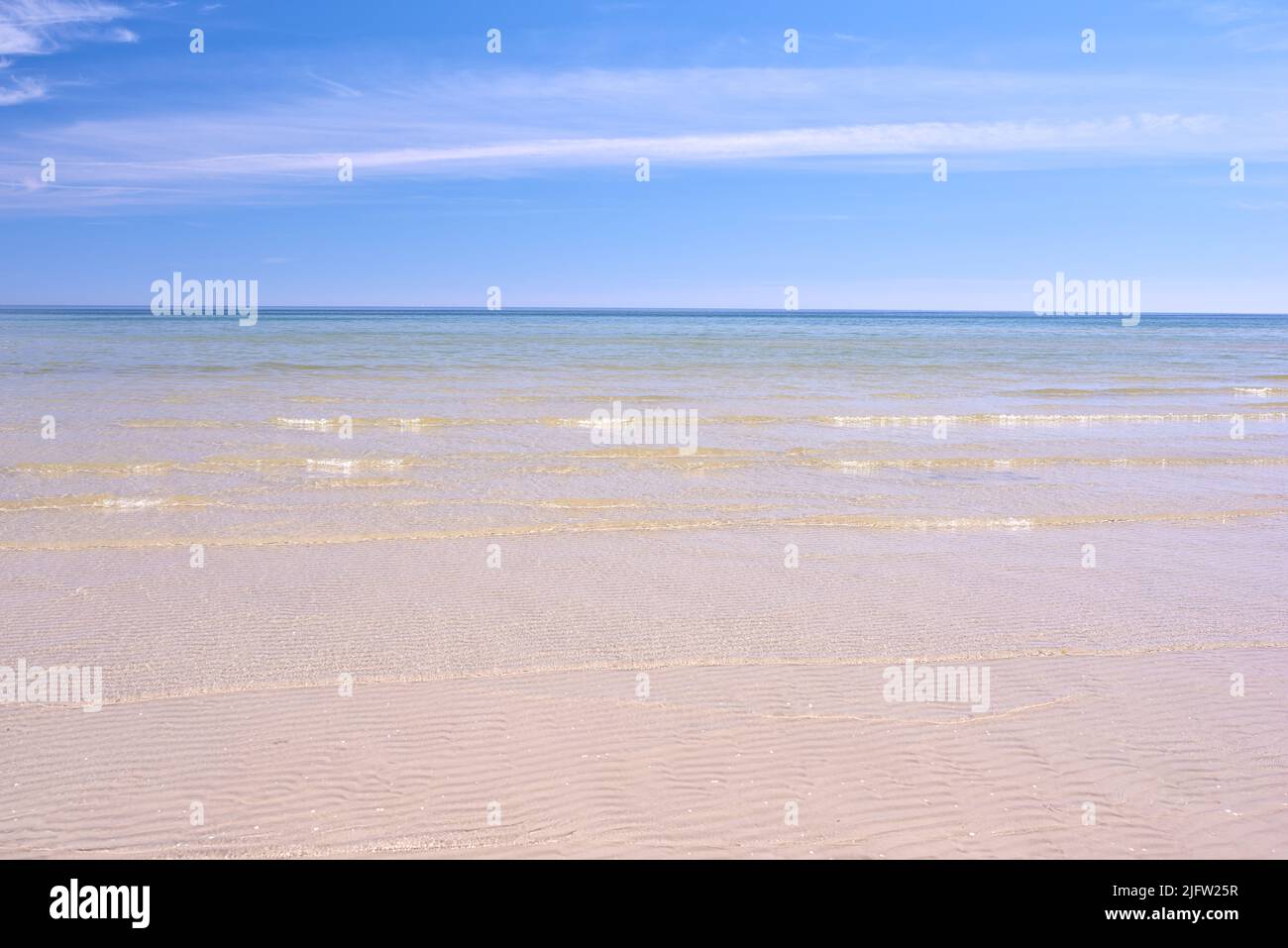 Copy space at the beach with a blue sky background above the horizon ...