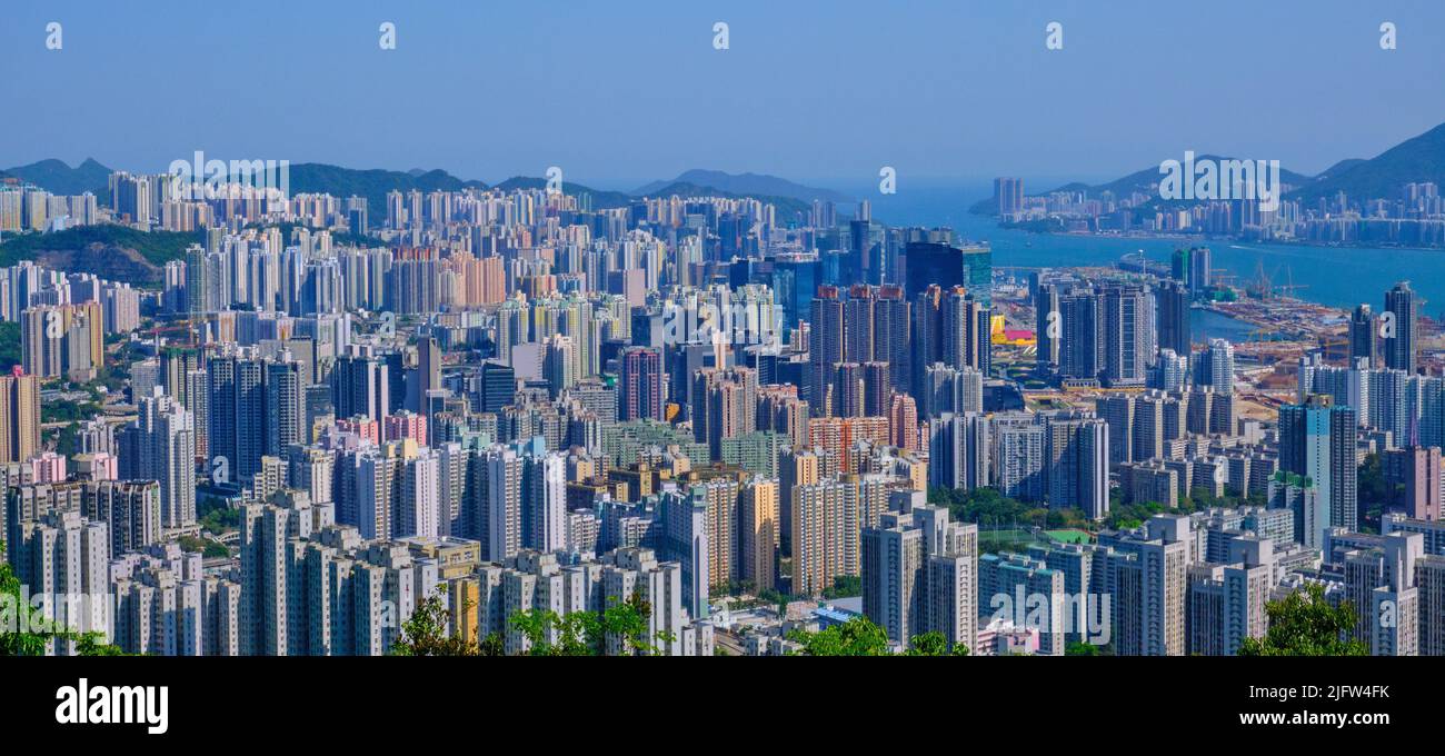 A bird's eye view of green hills against skyscrapers of Hing Kong on a ...