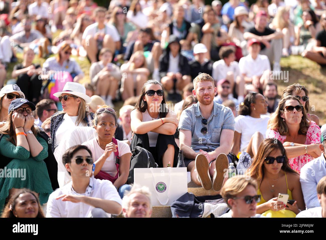 Spectators watch the action on the big screens on the hill outside ...