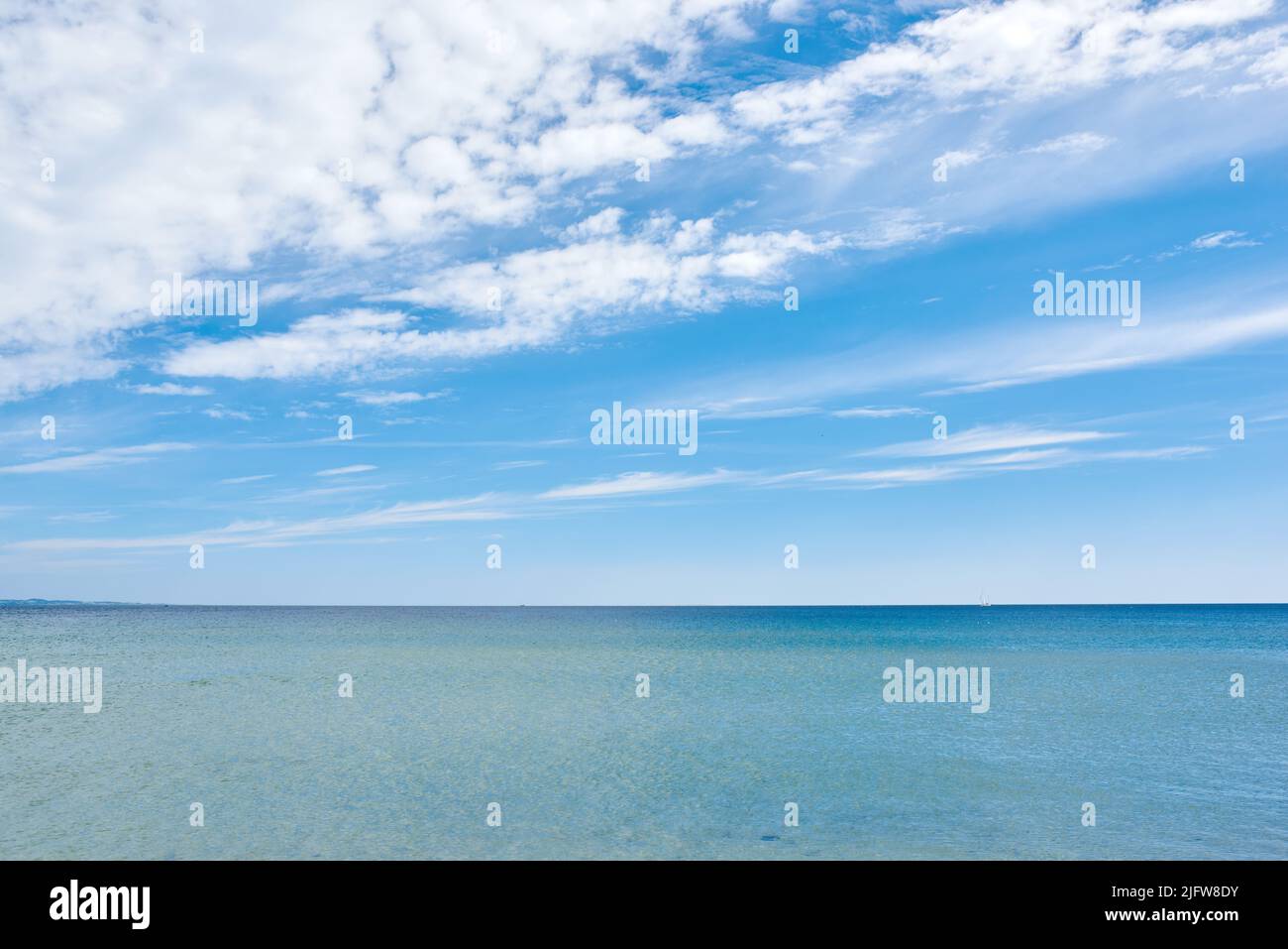 Copy space at sea with a cloudy blue sky background. Calm water surface ...
