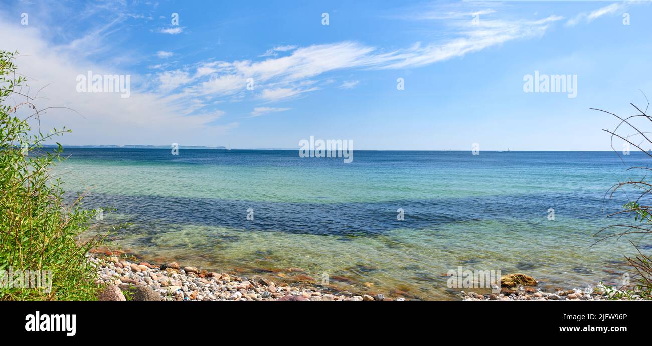 Copy space at sea with a cloudy blue sky background across the horizon ...