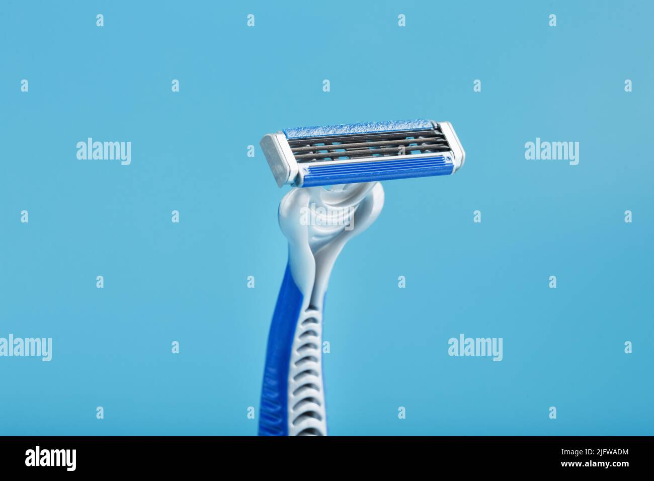 Blue shaving machine with sharp blades on the background of ice cubes ...