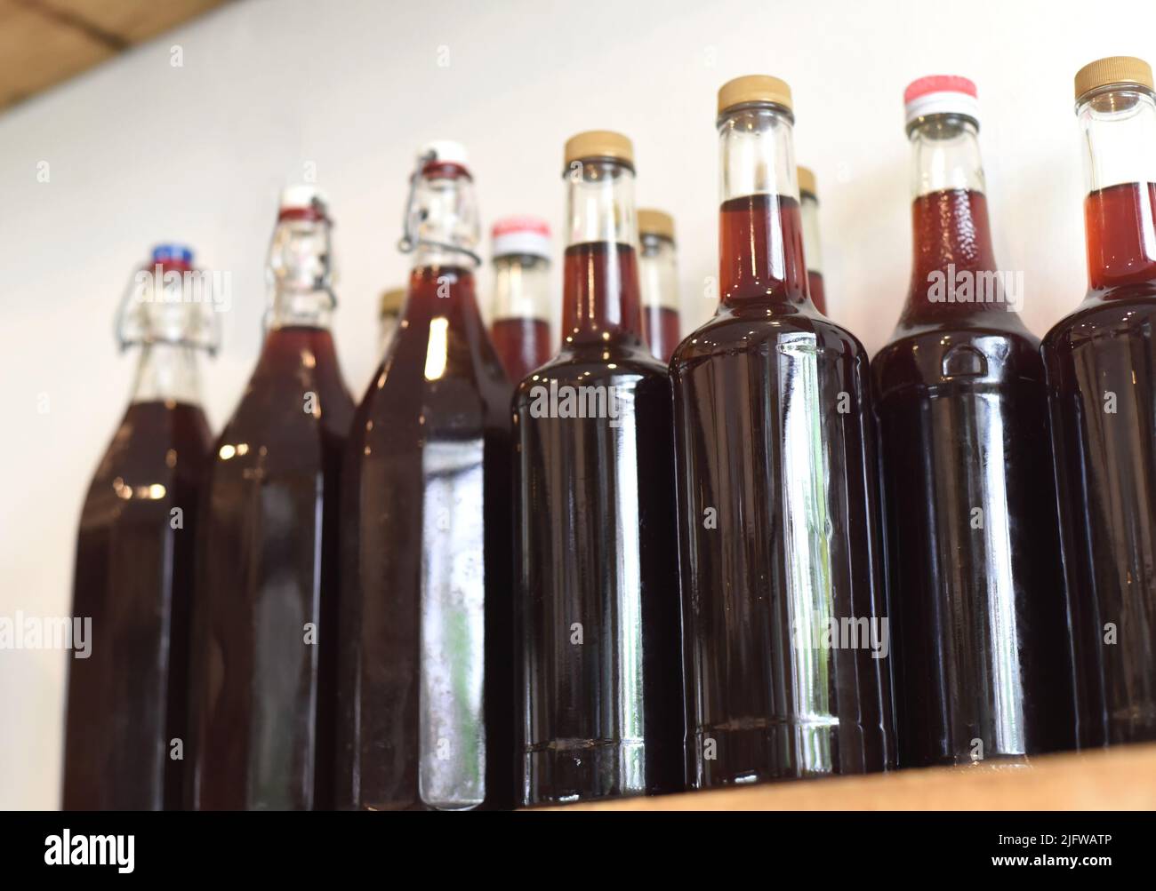 Homemade plum wine on a wooden shelf Stock Photo - Alamy