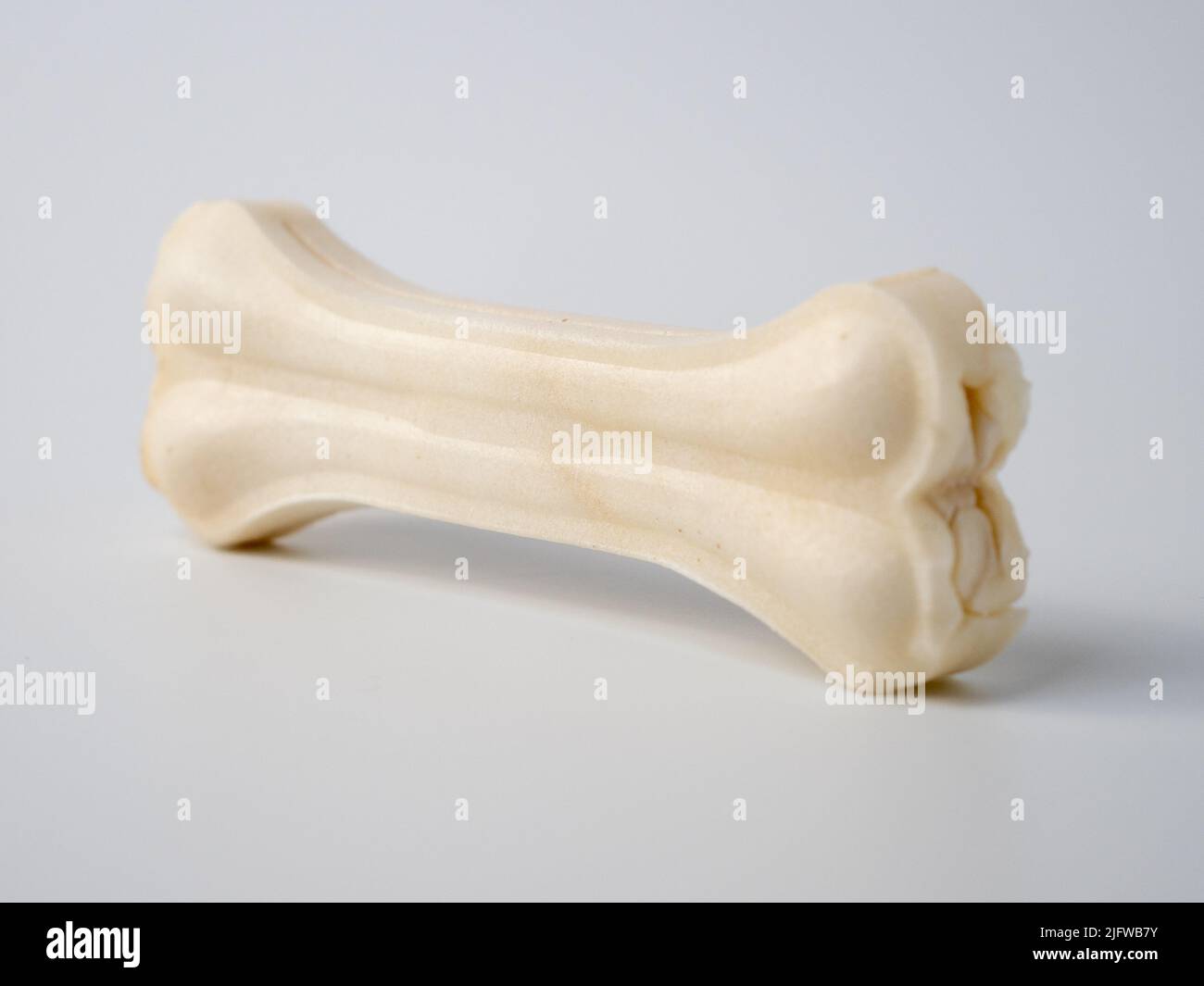 Pressed rawhide bone shaped dog chews isolated on a white background ...