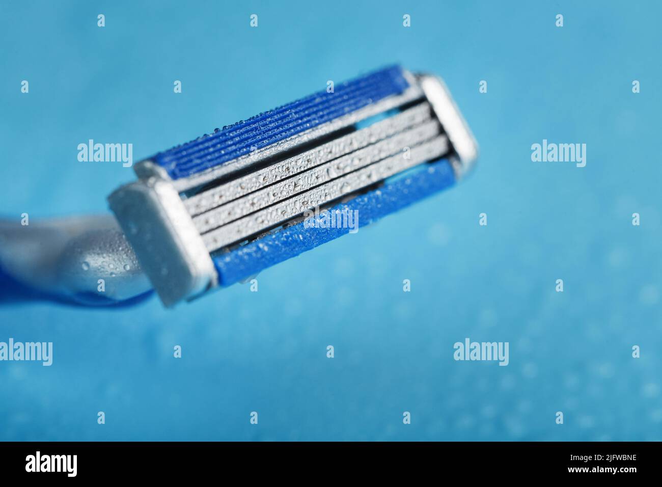 Three shaving machines on a blue background with free space, top view ...