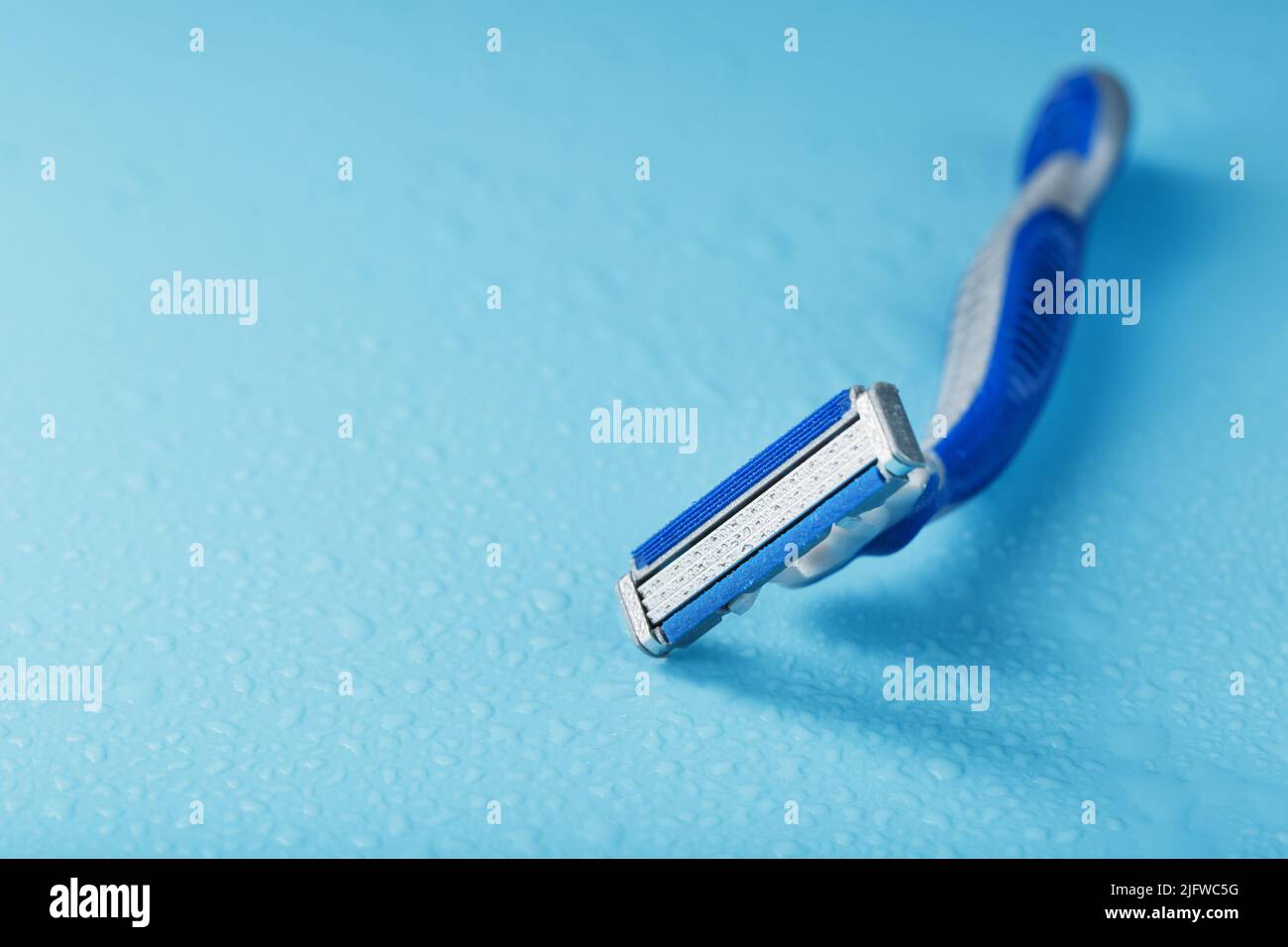 Three shaving machines on a blue background with free space, top view ...