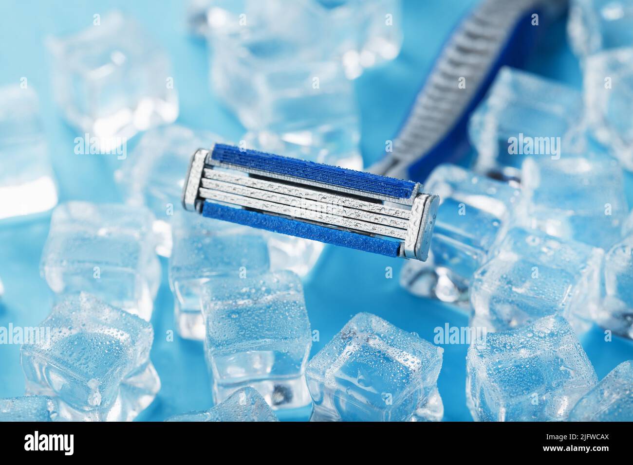 Blue shaving machines in a row on a blue background with ice cubes. The ...