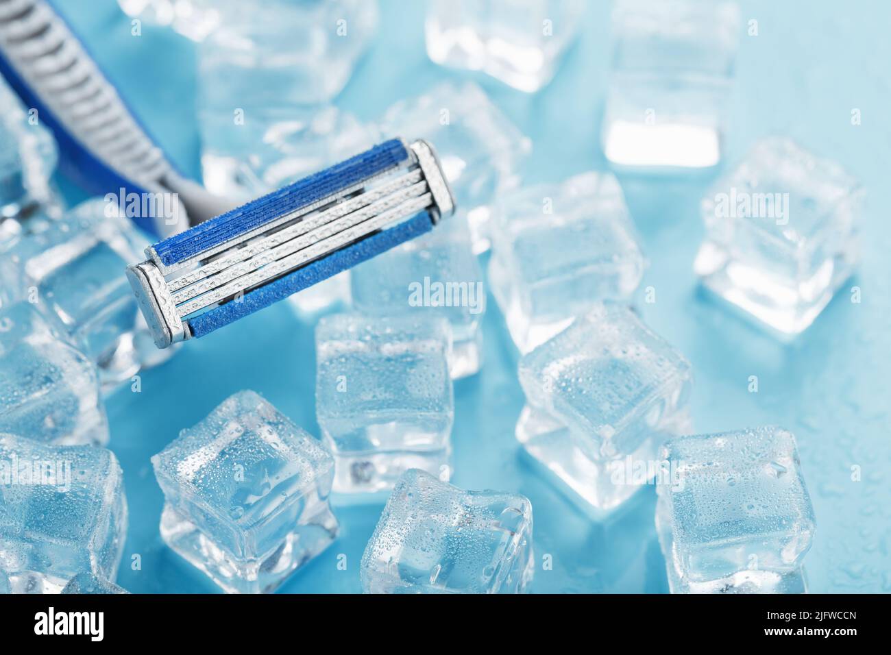 Shaving machine on a blue background with ice cubes. The concept of ...