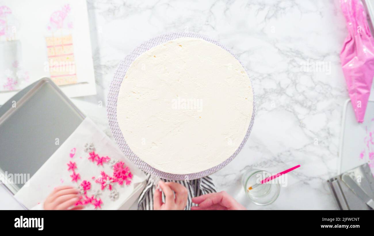 Flat lay. Step by step. Decorating round funfetti cake with pink and ...