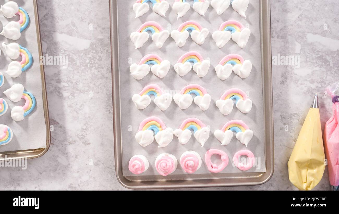 Flat lay. Step by step. Piping meringue mix into unicorn-shaped pops on ...