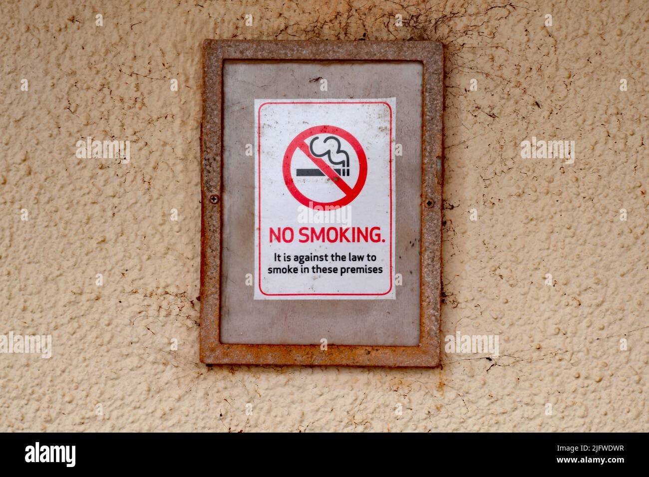 An old grungy sign in a bus shelter which prohibits smoking Stock Photo ...