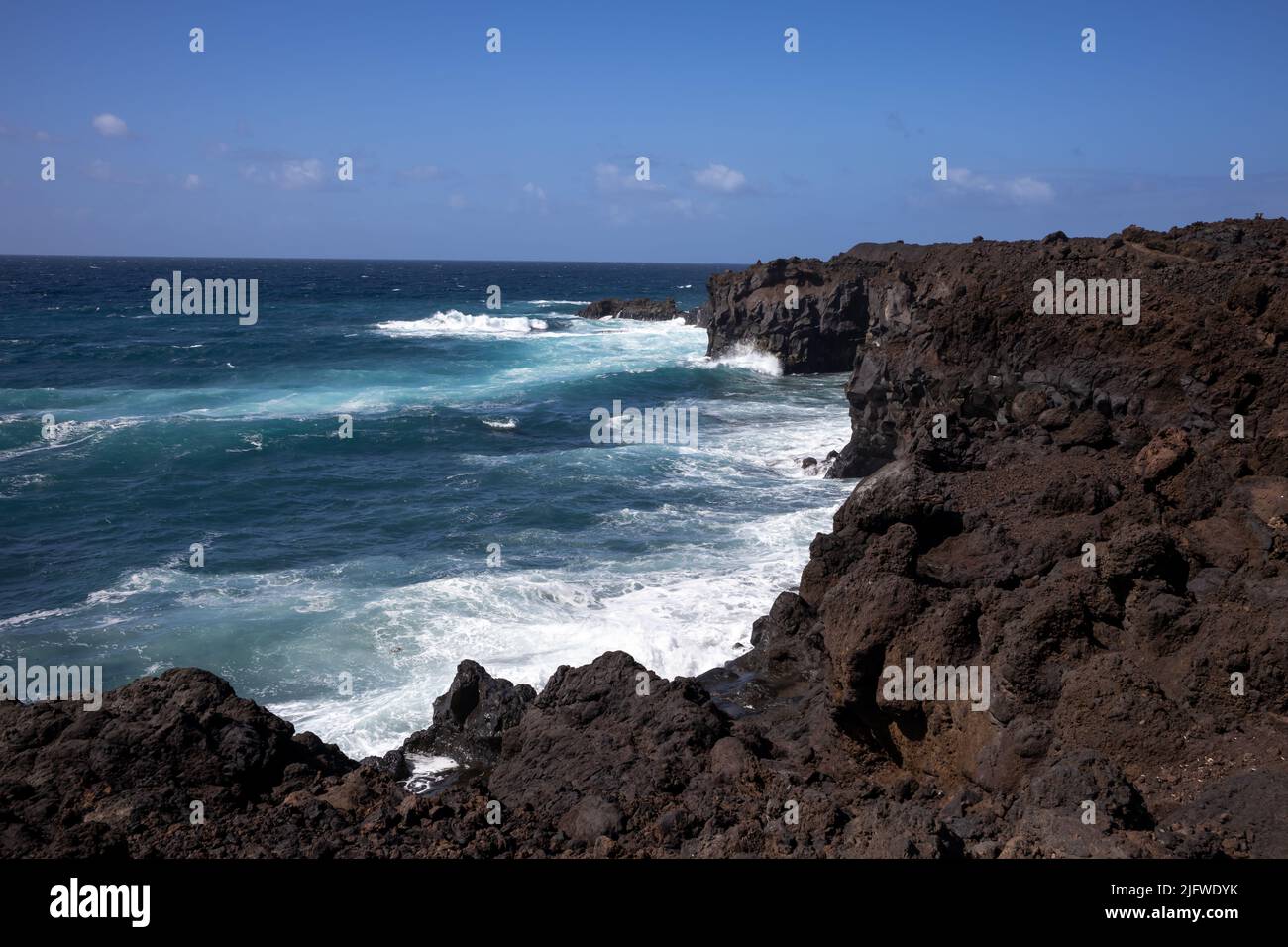 Rocks made of dark brown to black lava, creating the Atlantic ocean ...