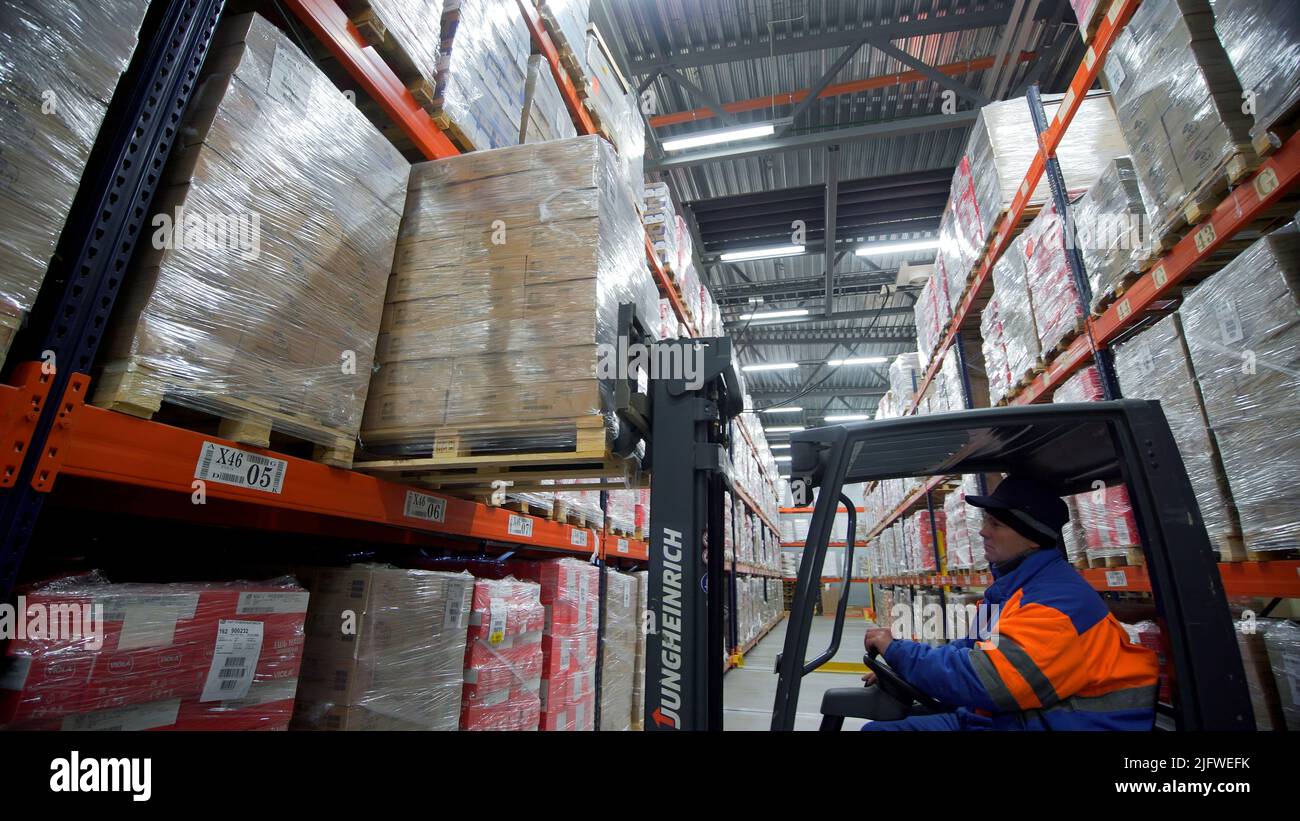 Moscow - Russia, 04.20.2022: Warehouse worker driver in uniform moving ...