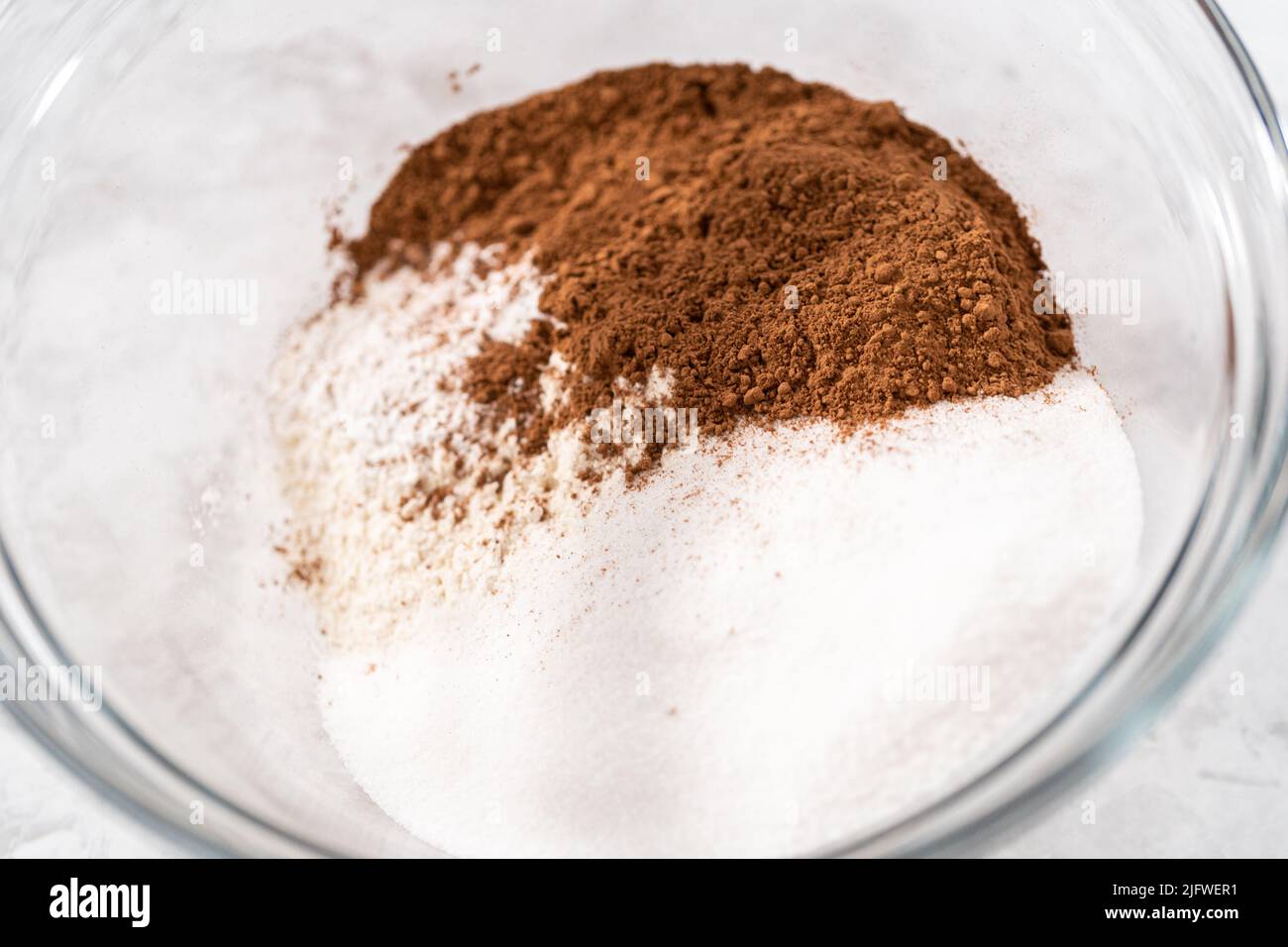 Mixing ingredients in a glass mixing bowl with a blending whisk to bake ...