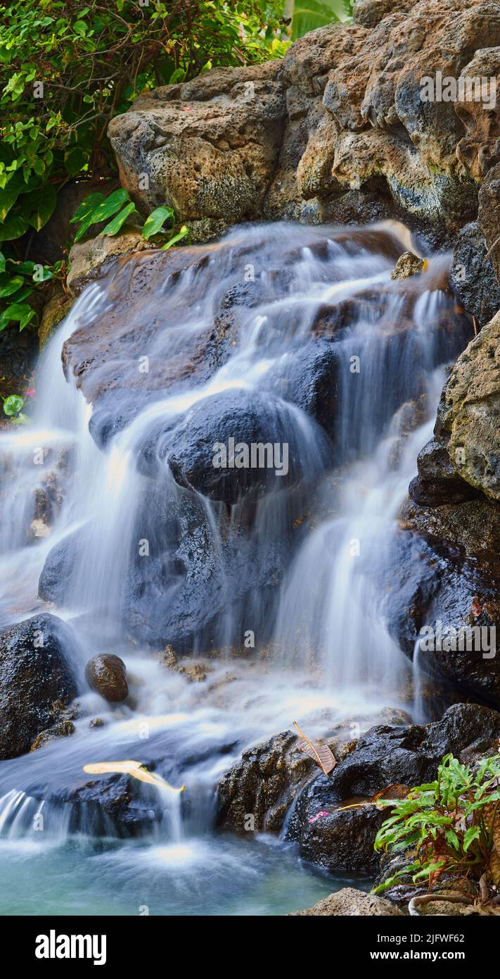 Serene pond with a waterfall over rocks. Landscape of a small natural ...