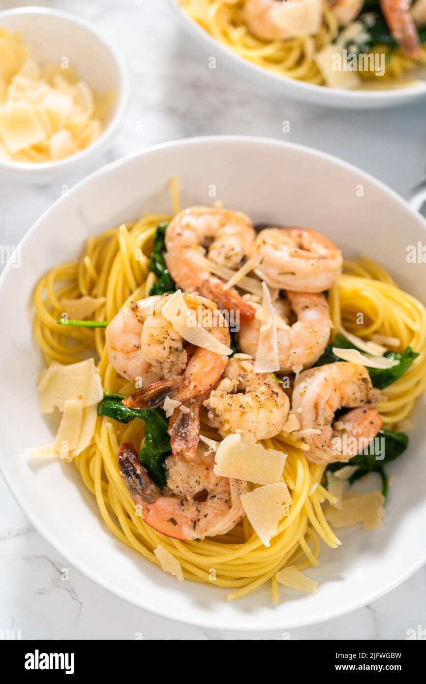 Serving Garlic Shrimp Pasta With Spinach In White Ceramic Bowls Stock
