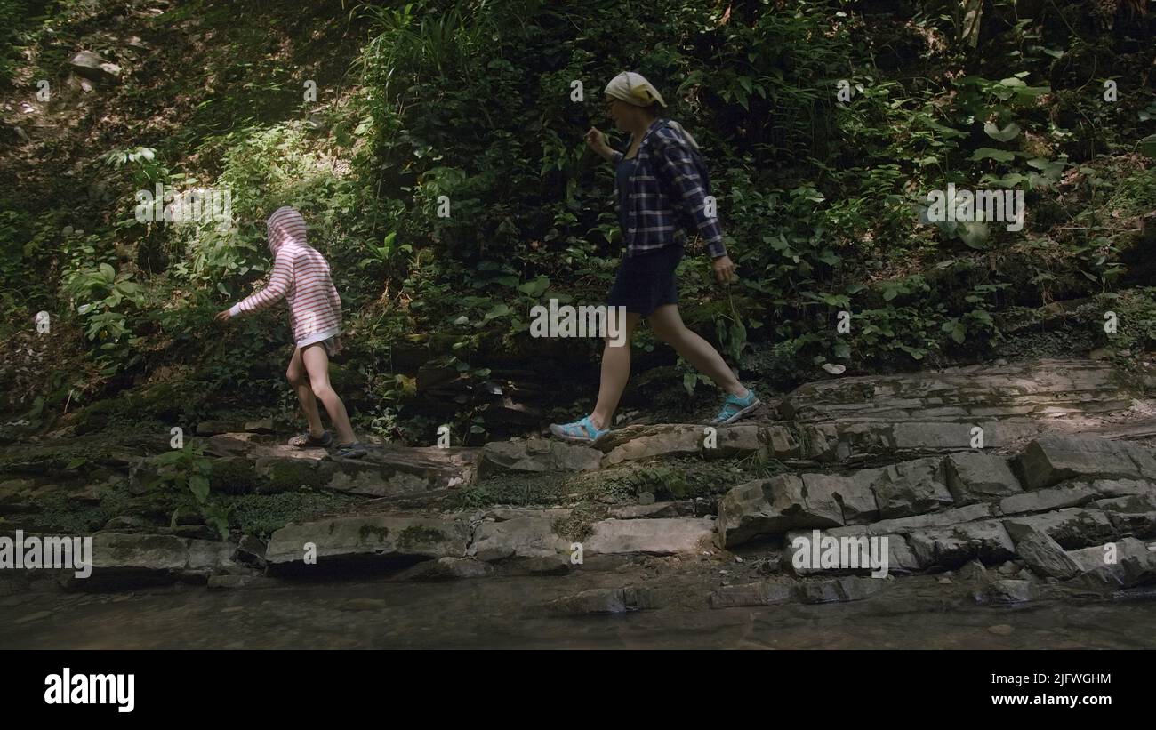 Hiking with hild in rocky jungle. Creative. Child and mother go hiking ...