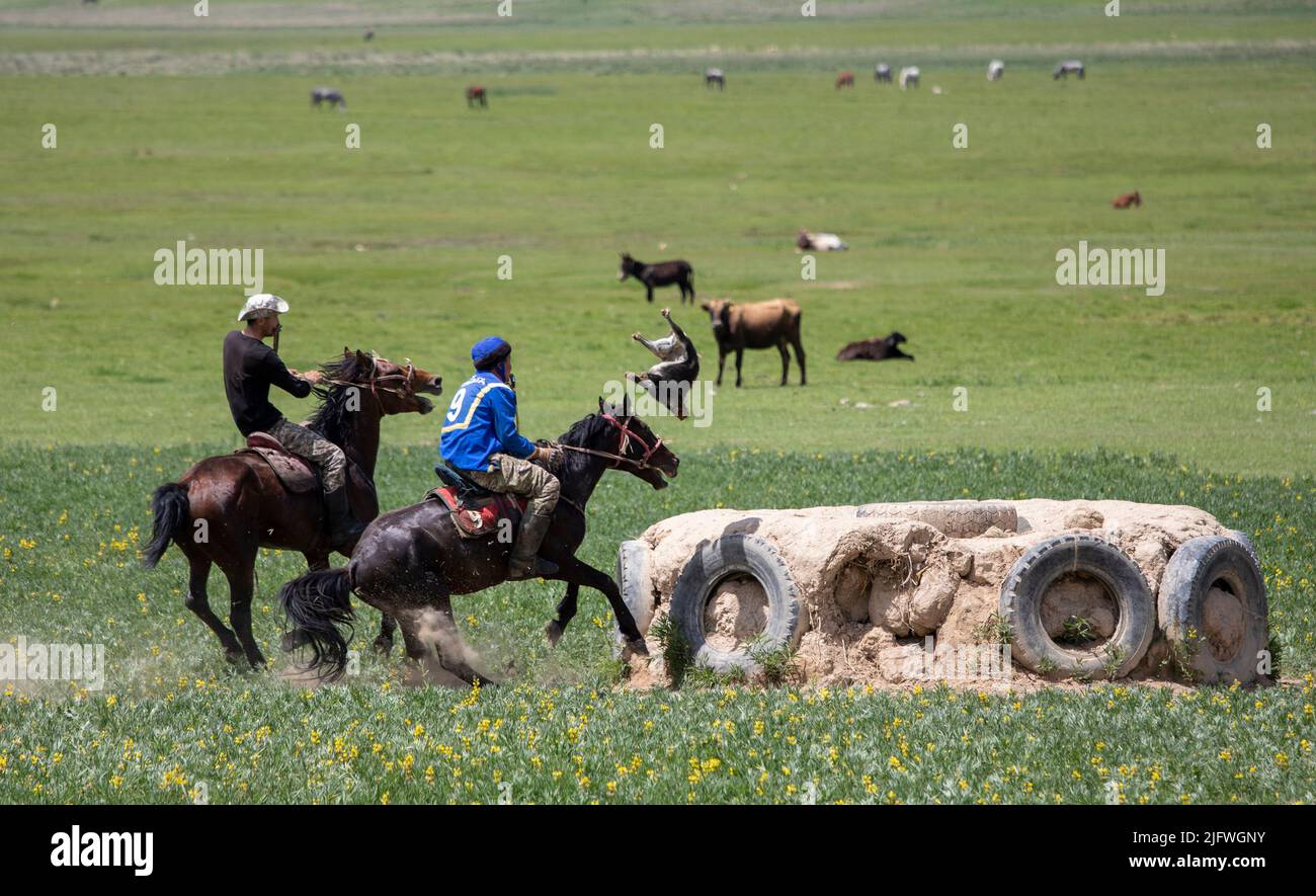 Men play a game of Kok Boru, or dead goat polo, in a field in ...