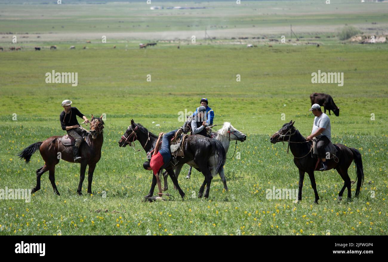 Men play a game of Kok Boru, or dead goat polo, in a field in ...