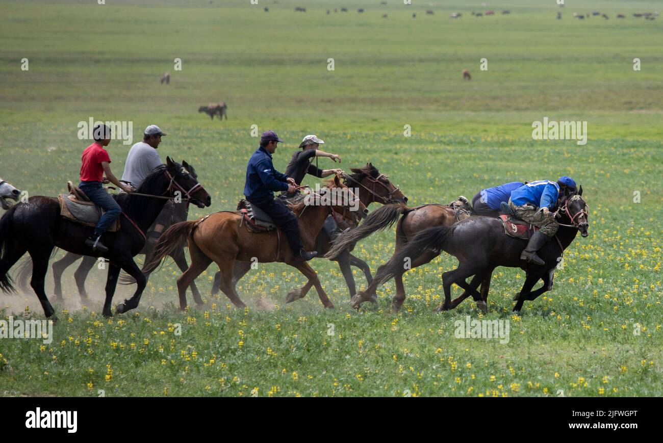 Men play a game of Kok Boru, or dead goat polo, in a field in ...