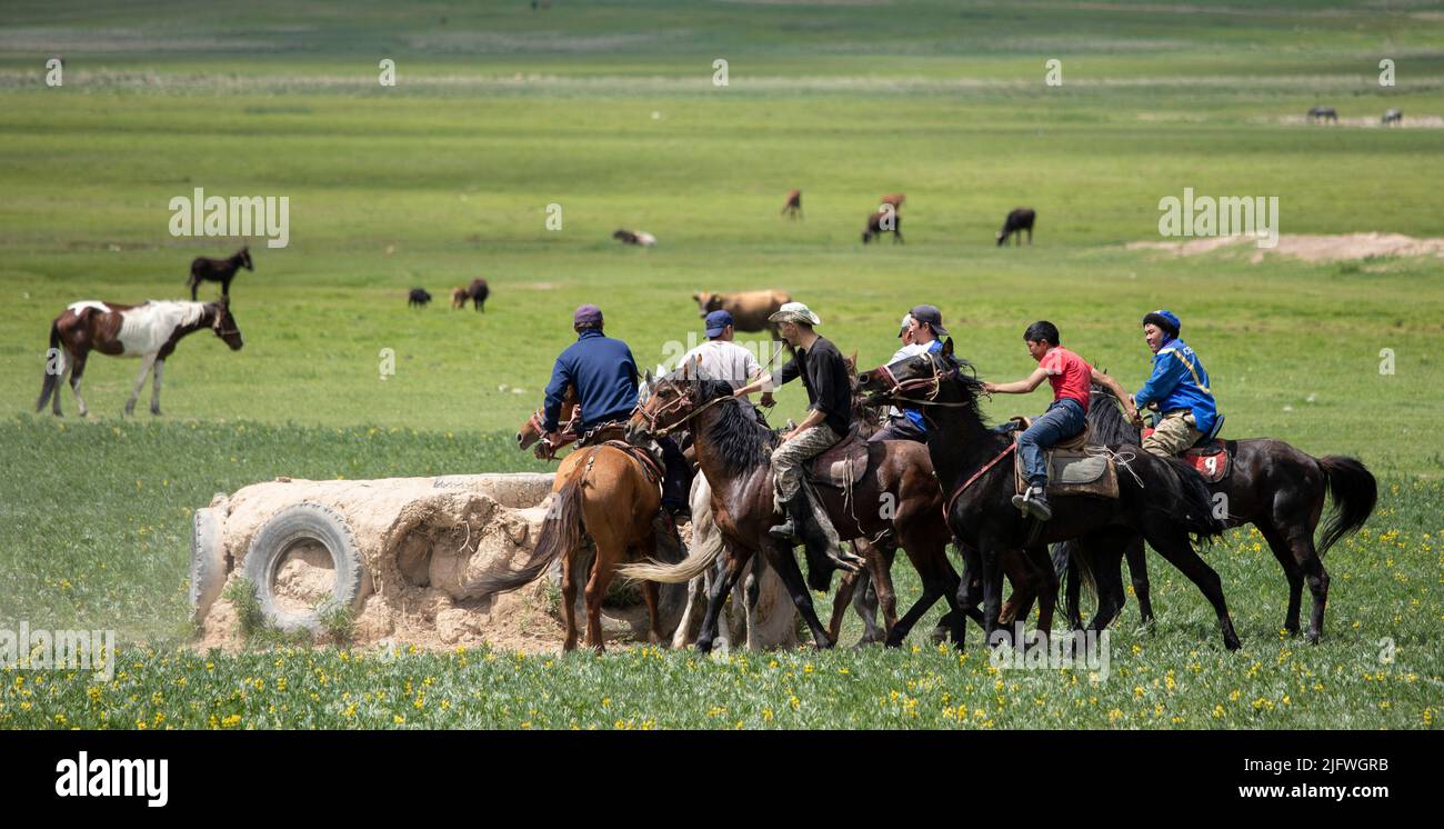 Men play a game of Kok Boru, or dead goat polo, in a field in ...