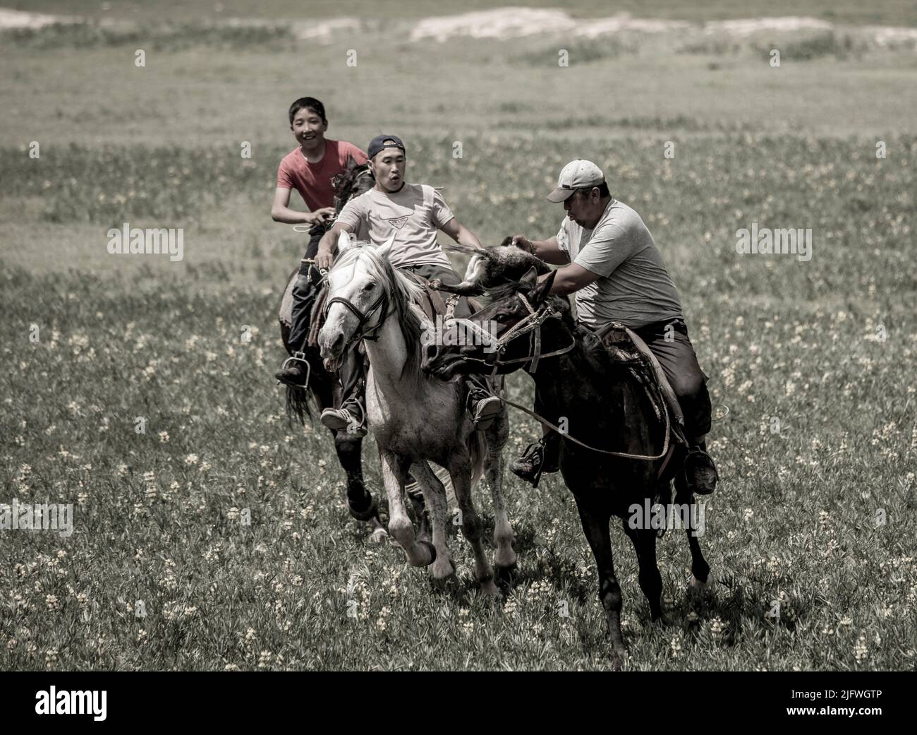 Men play a game of Kok Boru, or dead goat polo, in a field in ...