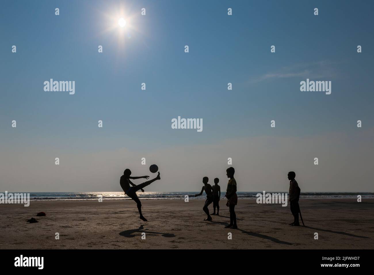 Playing football by the sea Stock Photo - Alamy