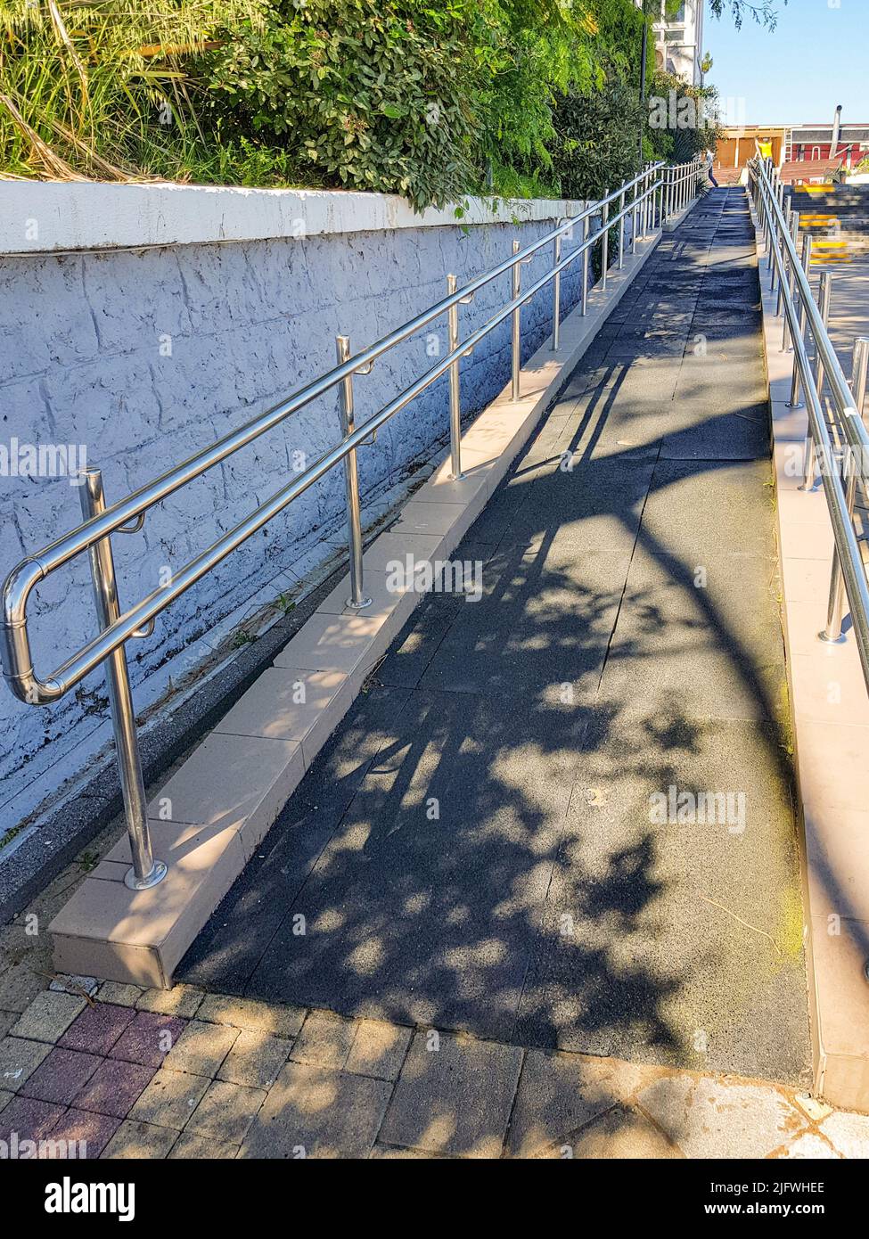 Modern ramp with shiny metal railings outdoors, wheelchair accessible ...