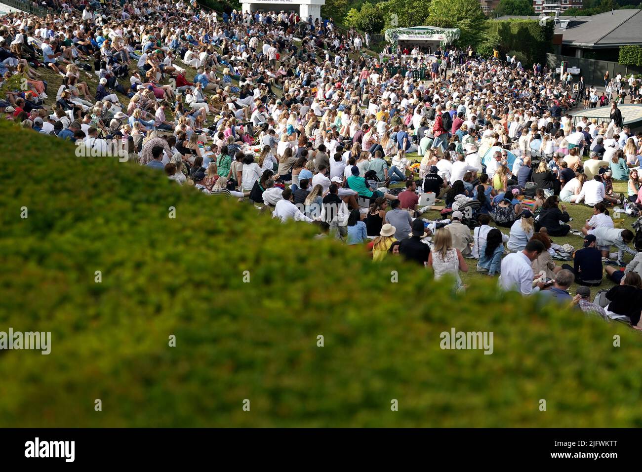 Spectators watch the action on the big screens on the hill outside ...