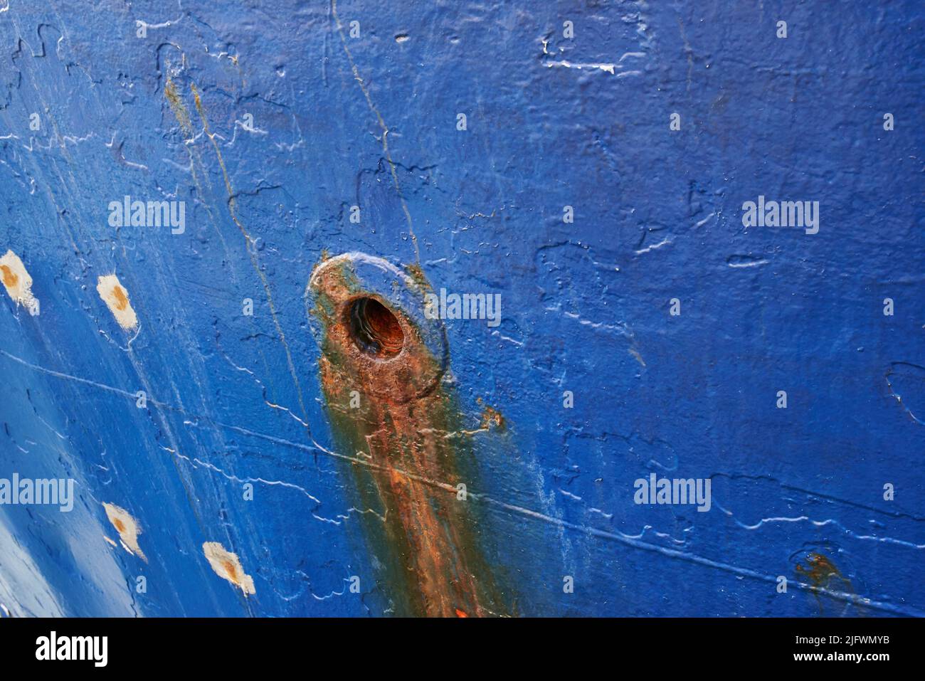 Abandoned and rusty limber hole on the side of docked ship outside ...
