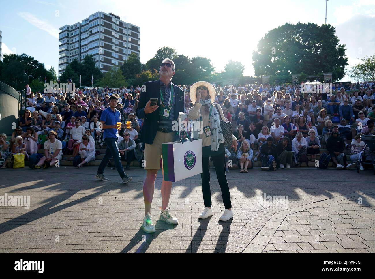 Spectators watch Cameron Norrie's match on the big screens on the hill ...