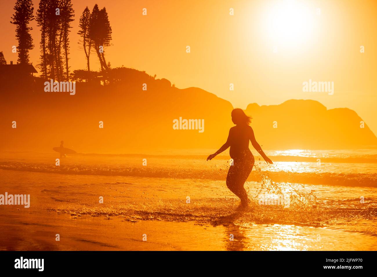 Happy pregnant woman on ocean coastline at tropical beach with sunrise ...