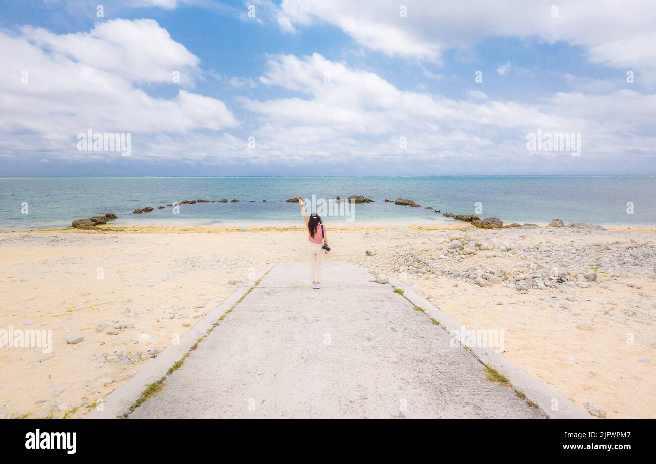 A female on the way to the Shiraho beach facing the horizon Stock Photo - Alamy