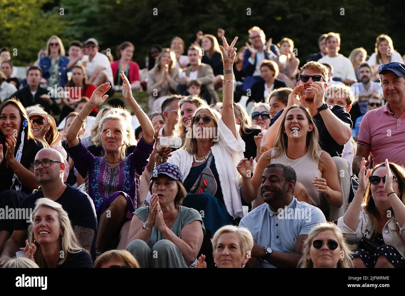 Spectators watch the action on the big screens on the hill outside ...