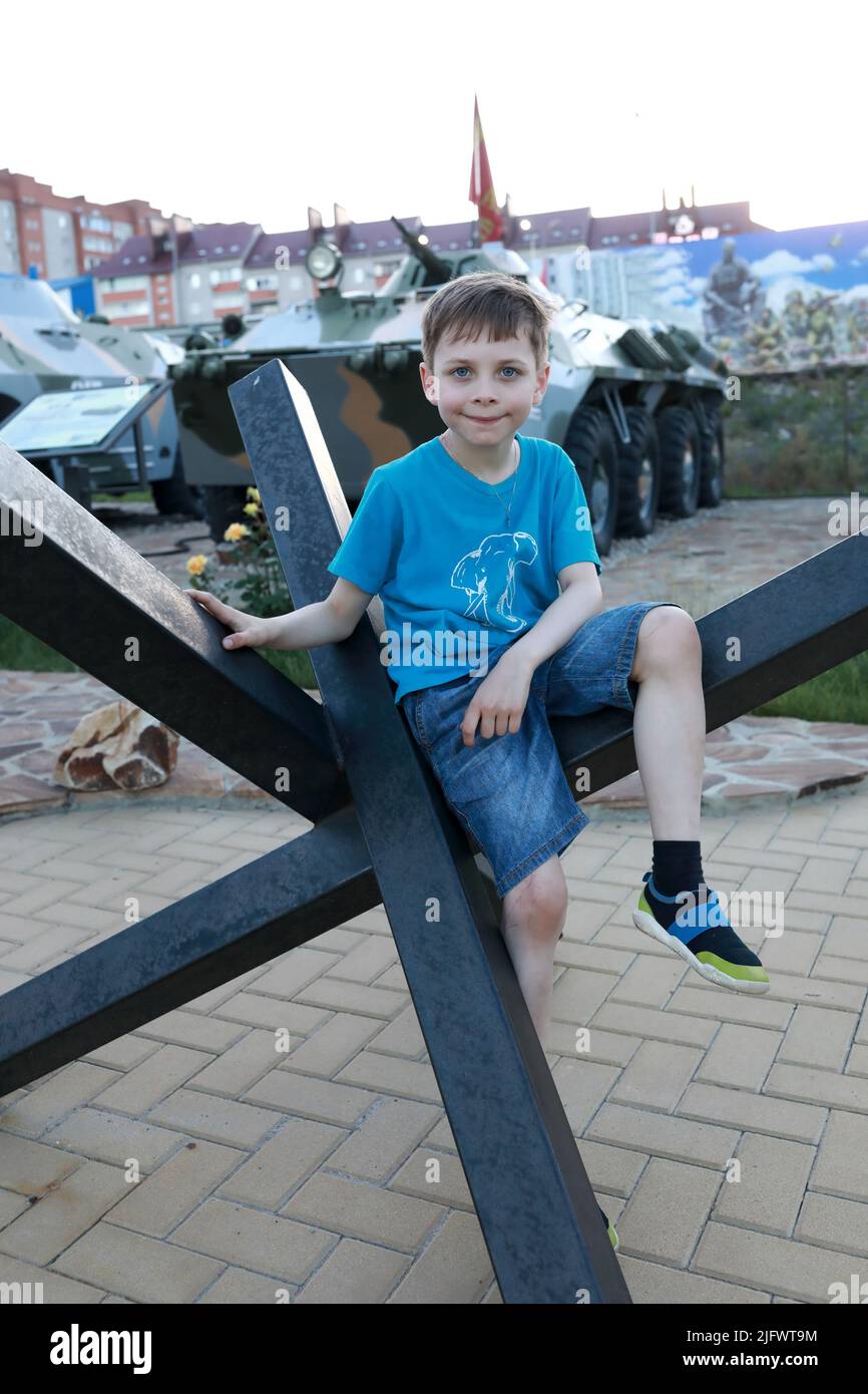 Portrait of child sitting on anti-tank hedgehog Stock Photo - Alamy