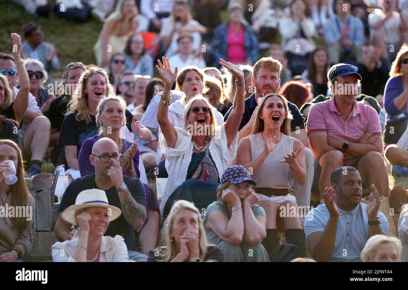 Spectators watch the action on the big screens on the hill outside ...